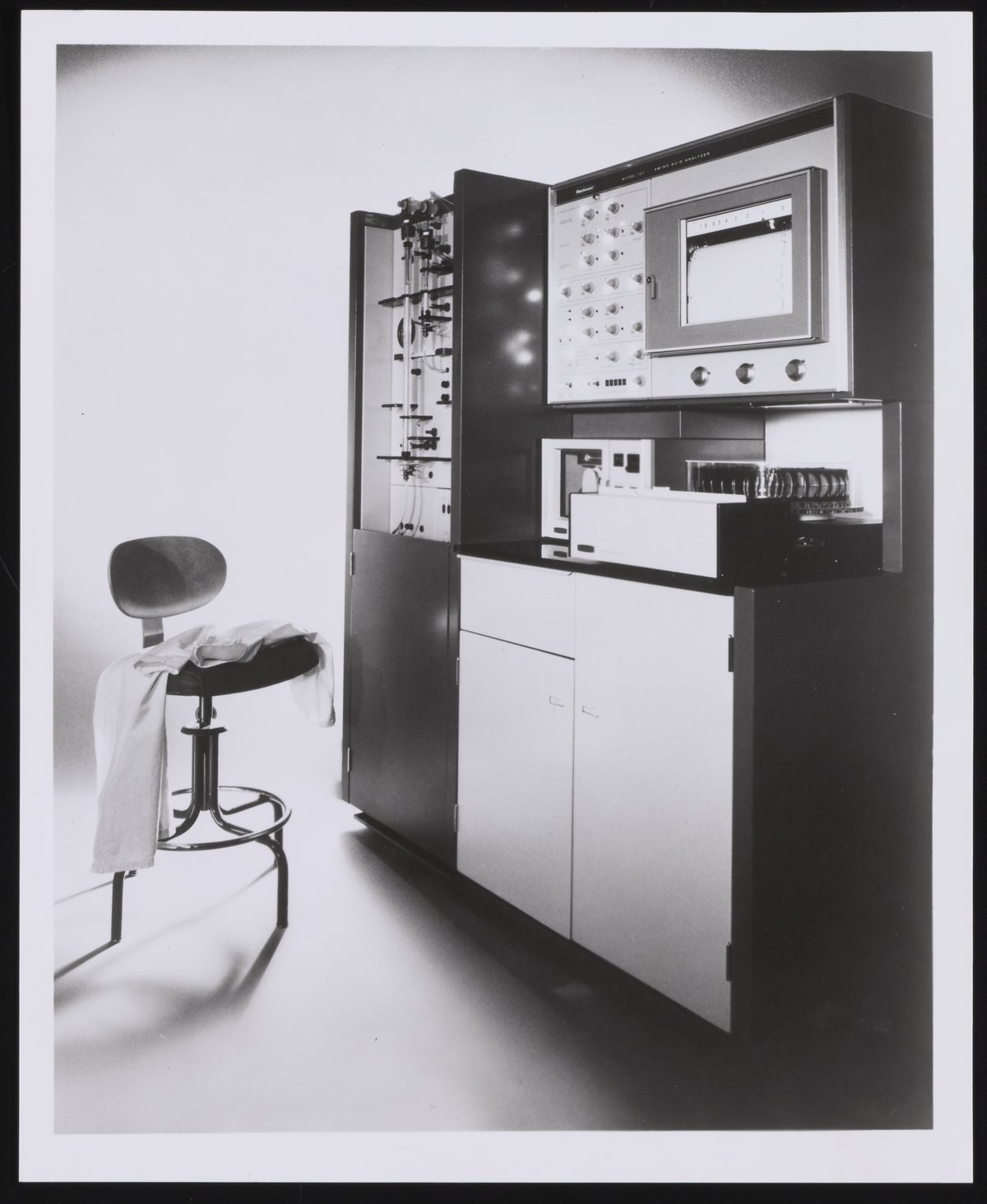 Beckman Model 121 Amino Acid Analyzer and a lab coat draped over an ...